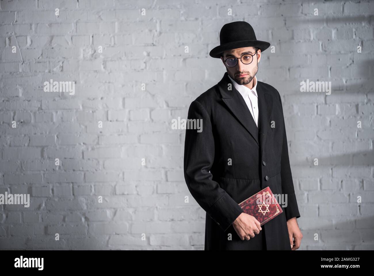 handsome and sad jewish man in glasses holding tanakh Stock Photo - Alamy