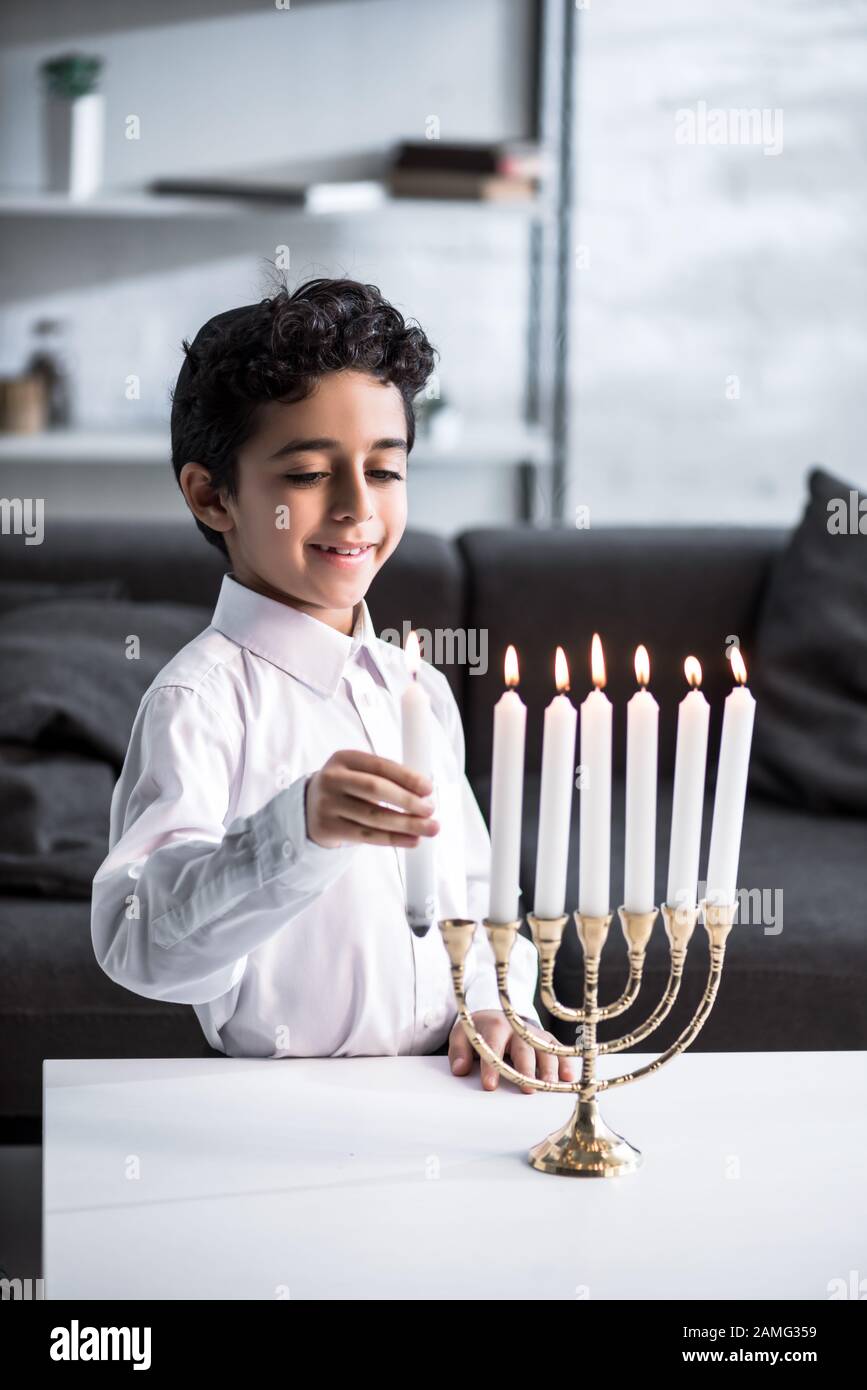 cute and smiling jewish boy in shirt holding candle Stock Photo - Alamy