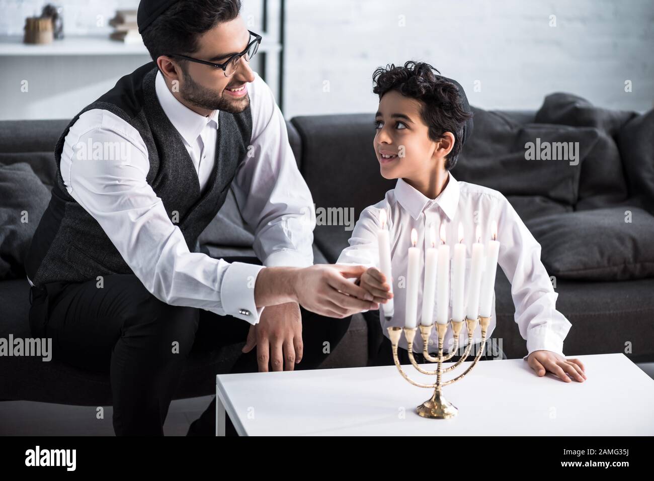 smiling jewish father and son holding candle in apartment Stock Photo ...