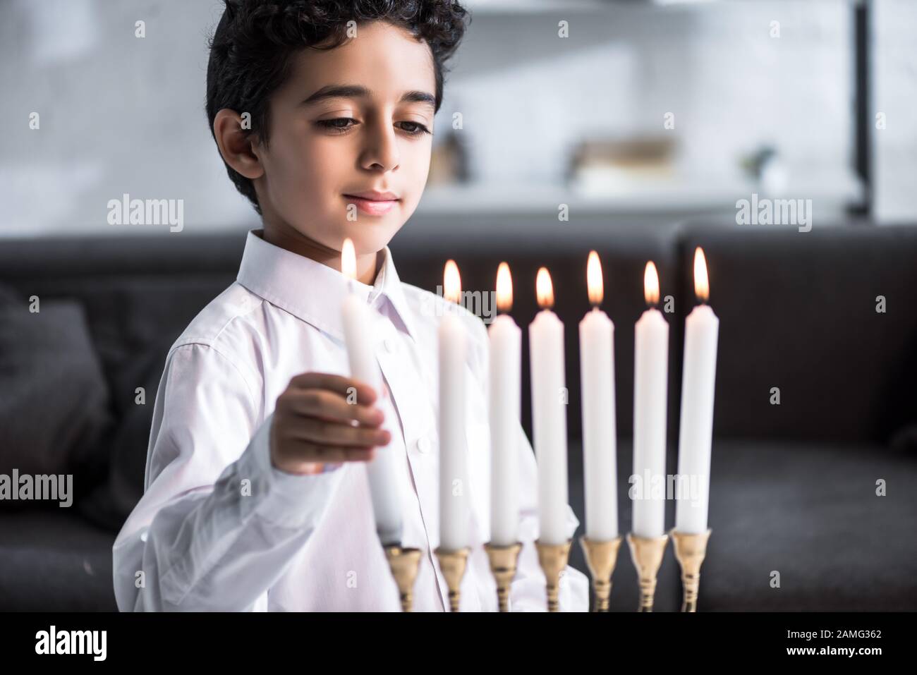 cute and smiling jewish boy in shirt holding candle Stock Photo - Alamy