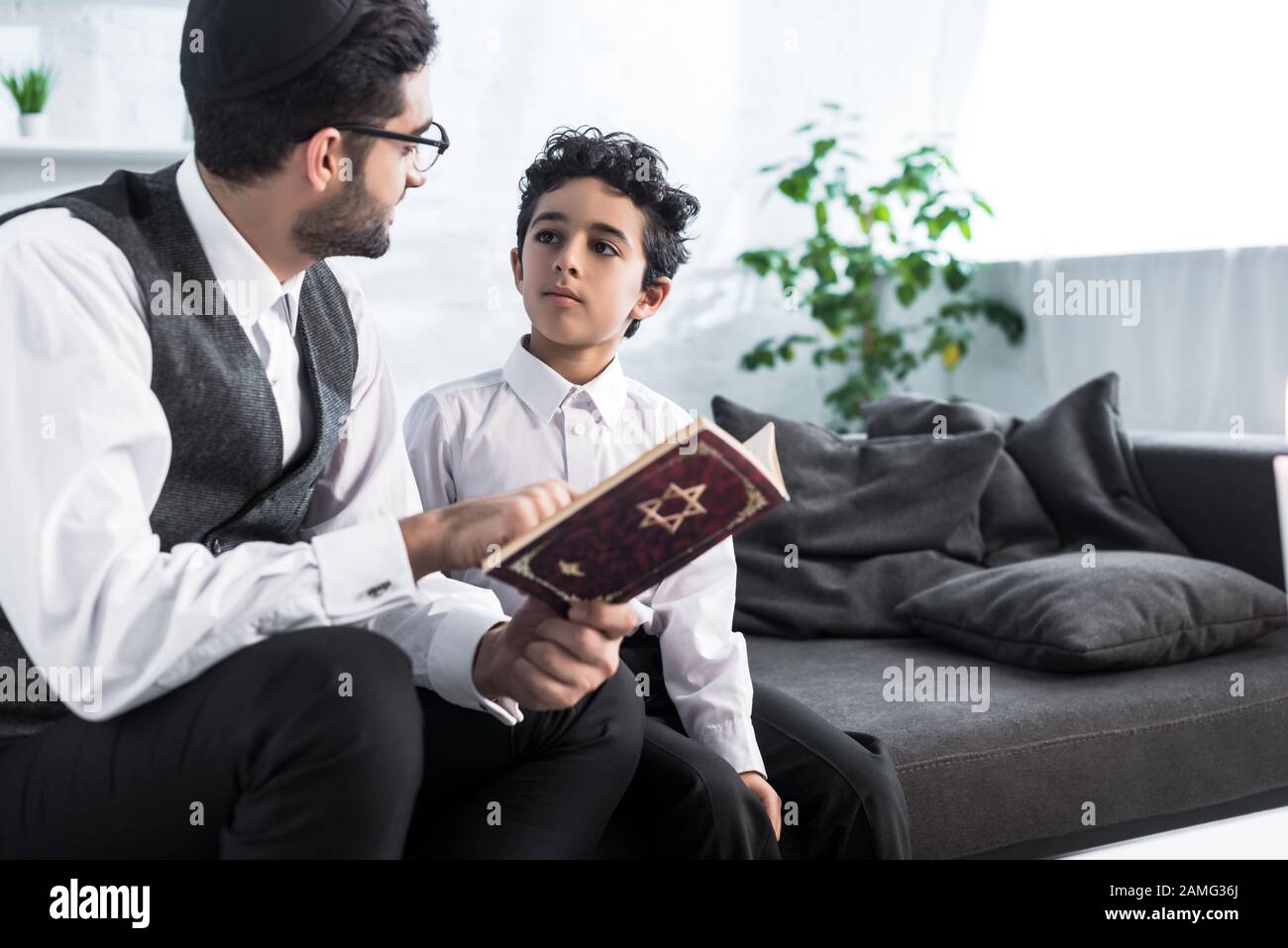 jewish father and son talking and holding tanakh in apartment Stock ...