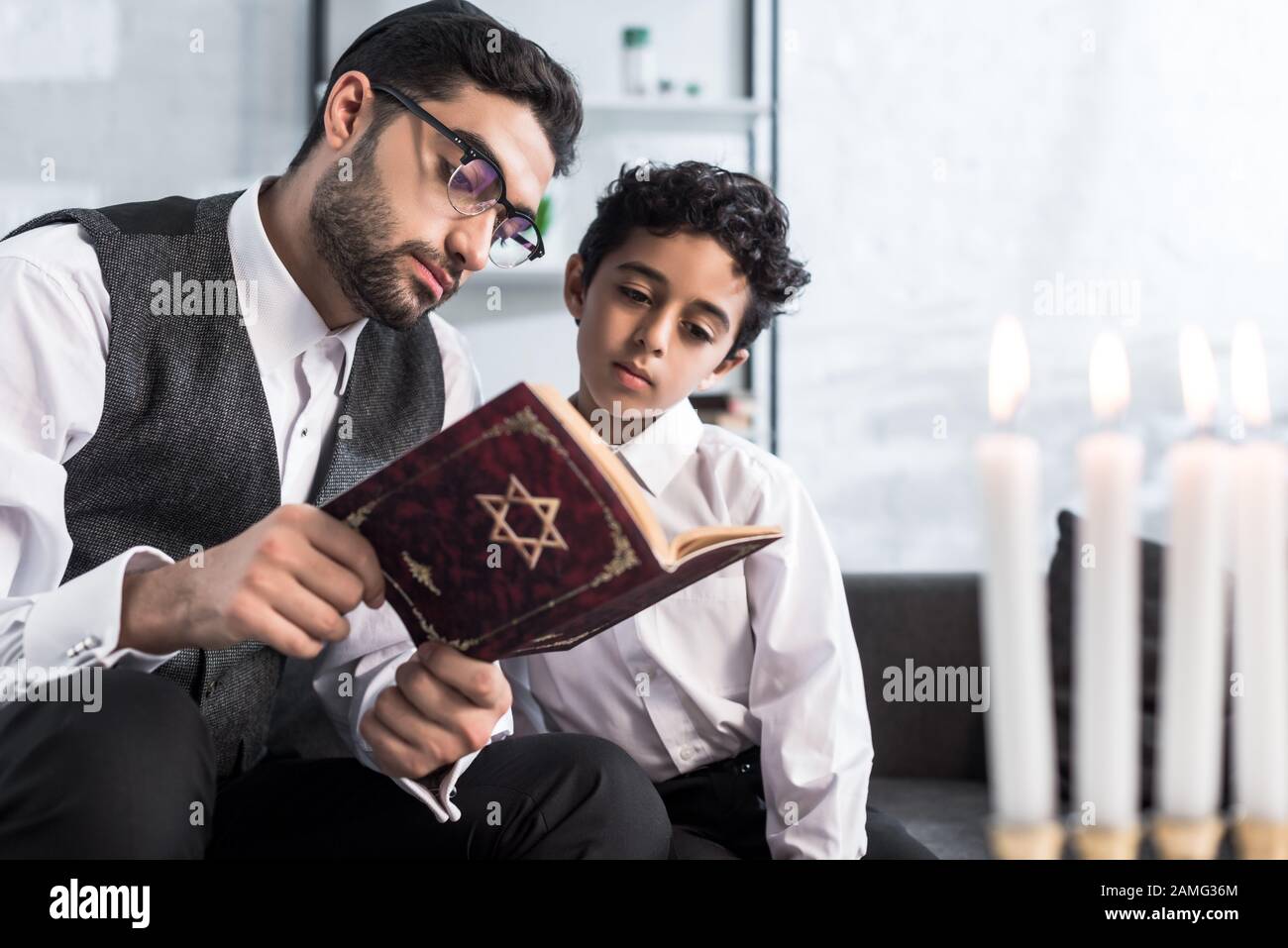 handsome jewish father and son reading tanakh in apartment Stock Photo ...