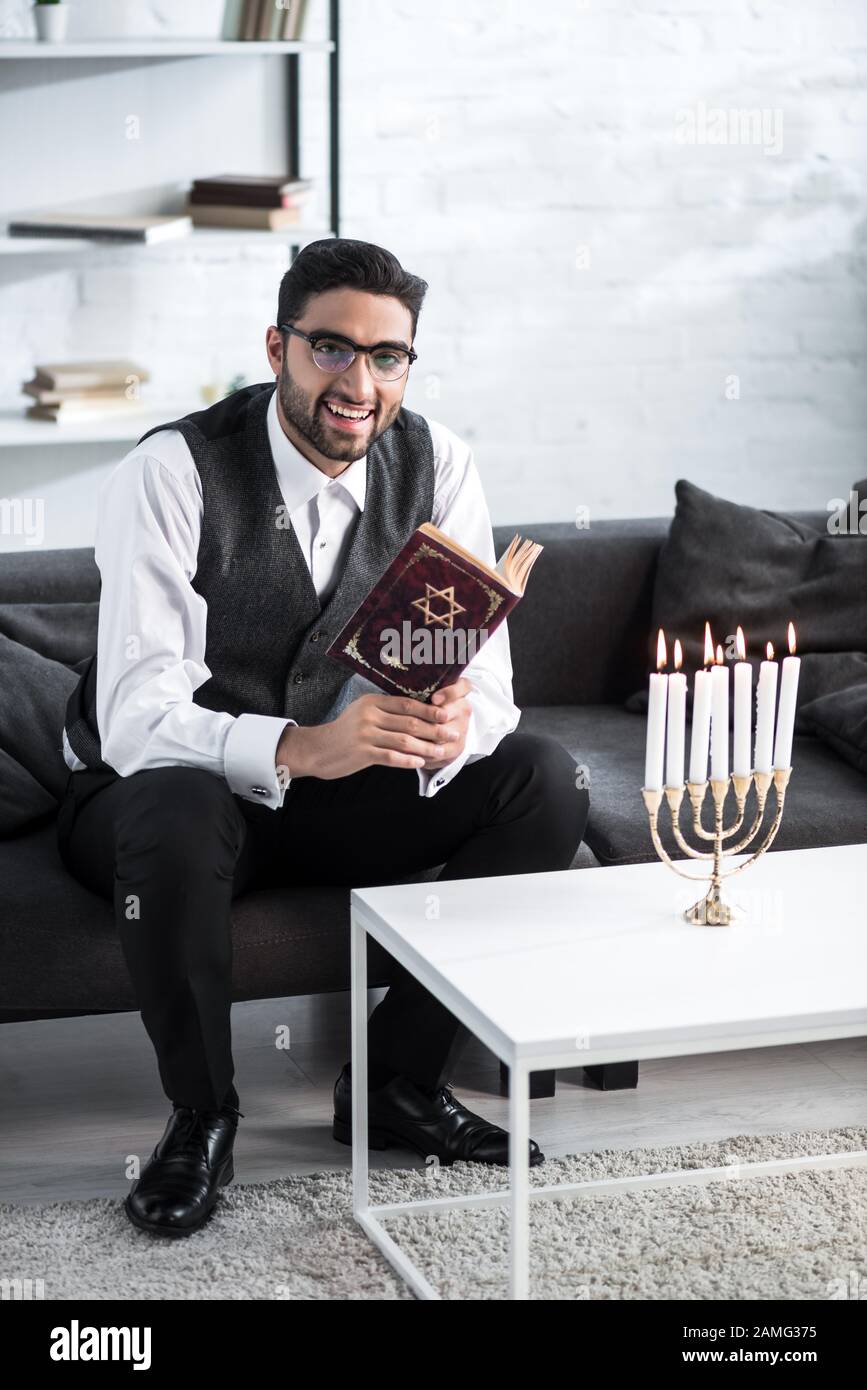 handsome and smiling jewish man in glasses holding tanakh Stock Photo ...