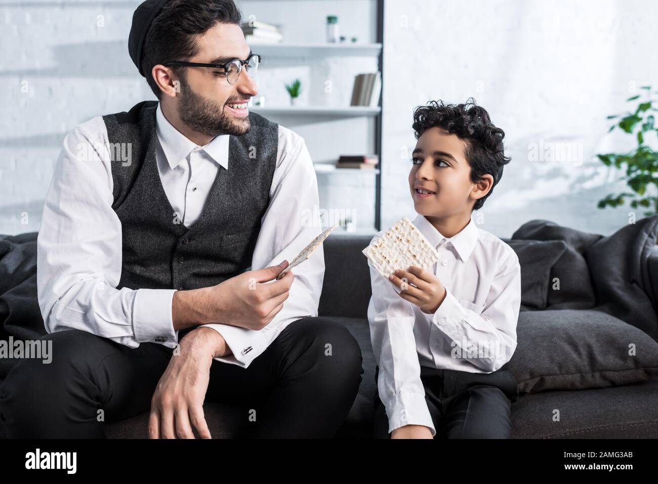 smiling jewish father and son holding matza in apartment Stock Photo ...