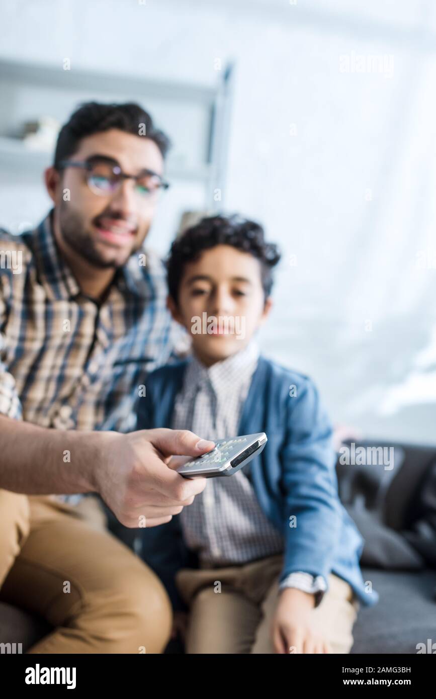 selective focus of smiling jewish father with remote controller ...