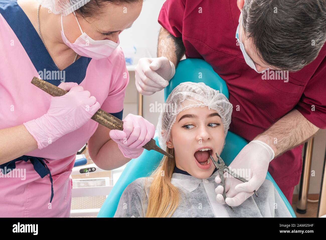 dentist wants to pull out teeth to a frightened patient with pliers ...