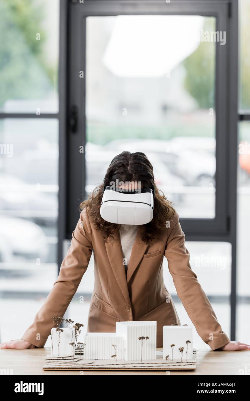 virtual reality architect in virtual reality headset looking at model ...