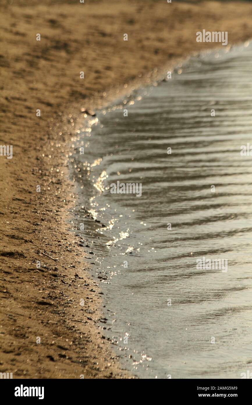 Close-up of lake water touching the shore Stock Photo - Alamy