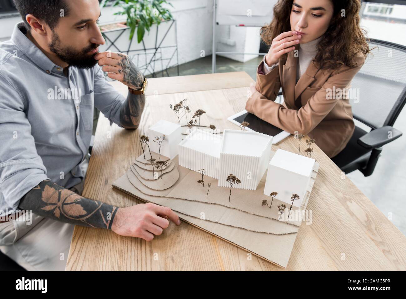 cropped view of pensive virtual reality architects looking at model of ... cropped view of pensive virtual reality architects looking at model of ...