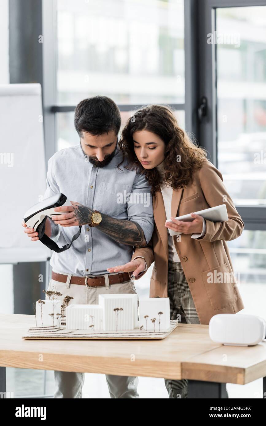 virtual reality architects looking at model of house on table Stock ...