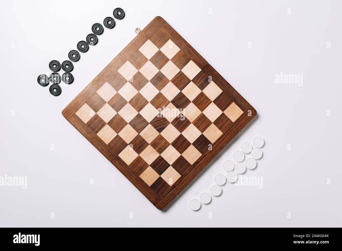 Top view of wooden chessboard and checkers on white background Stock ...