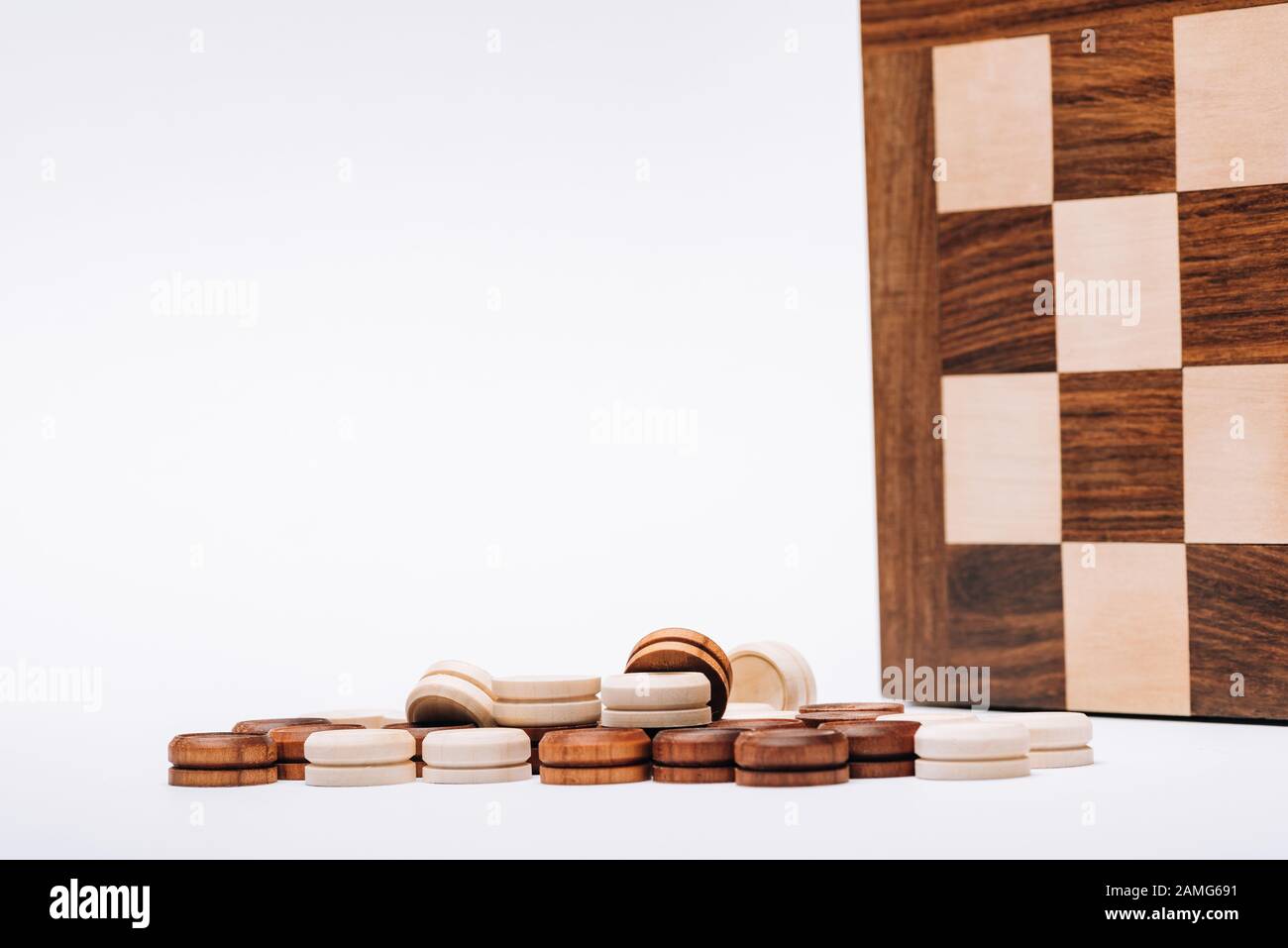 Wooden checkers by checkerboard isolated on white Stock Photo - Alamy