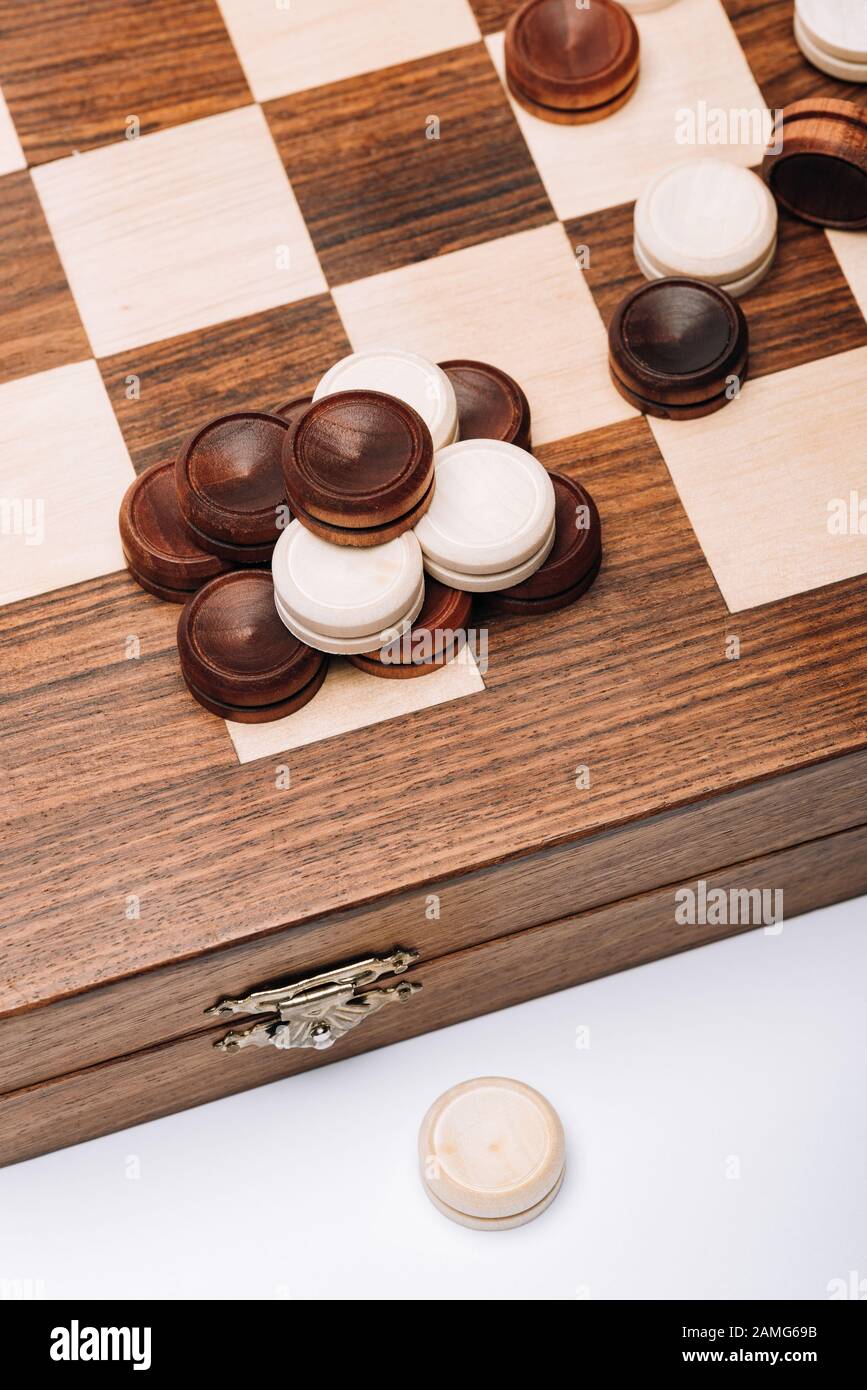 High angle view of wooden checkers on checkerboard isolated on white ...