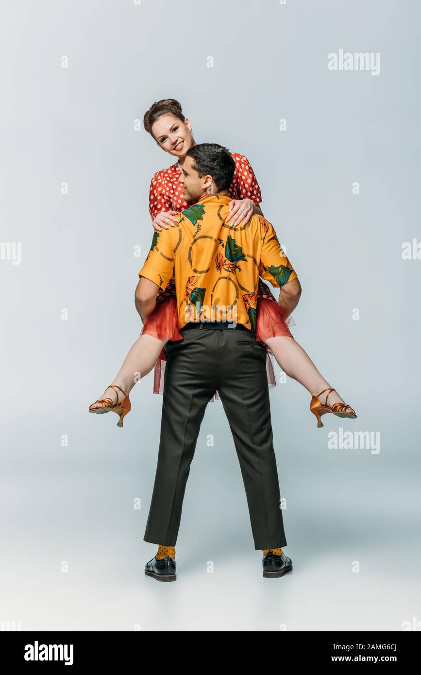 back view of dancer holding cheerful girl while dancing boogie-woogie ...