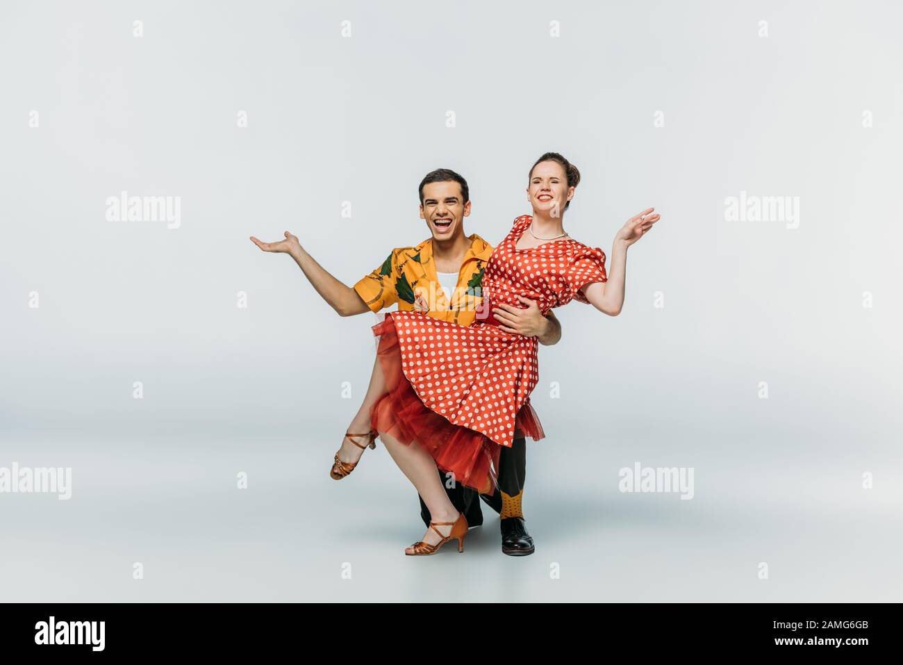 handsome dancer standing on knee and supporting partner while dancing ...