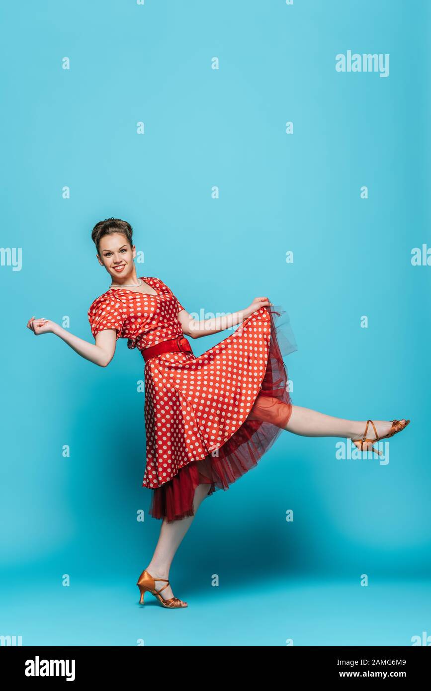 pretty, smiling dancer looking at camera while dancing boogie-woogie on ...