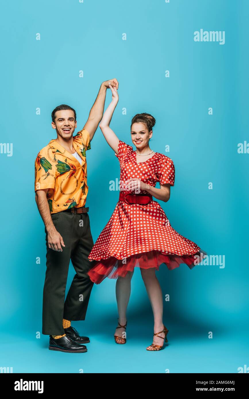 happy dancers holding hands while dancing boogie-woogie on blue ...