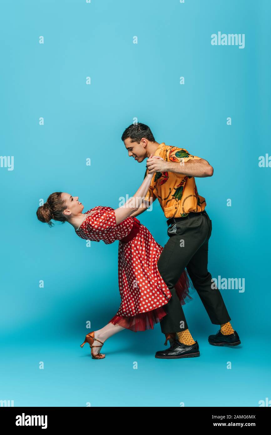 side view of young dancers holding hands while dancing boogie-woogie on ...