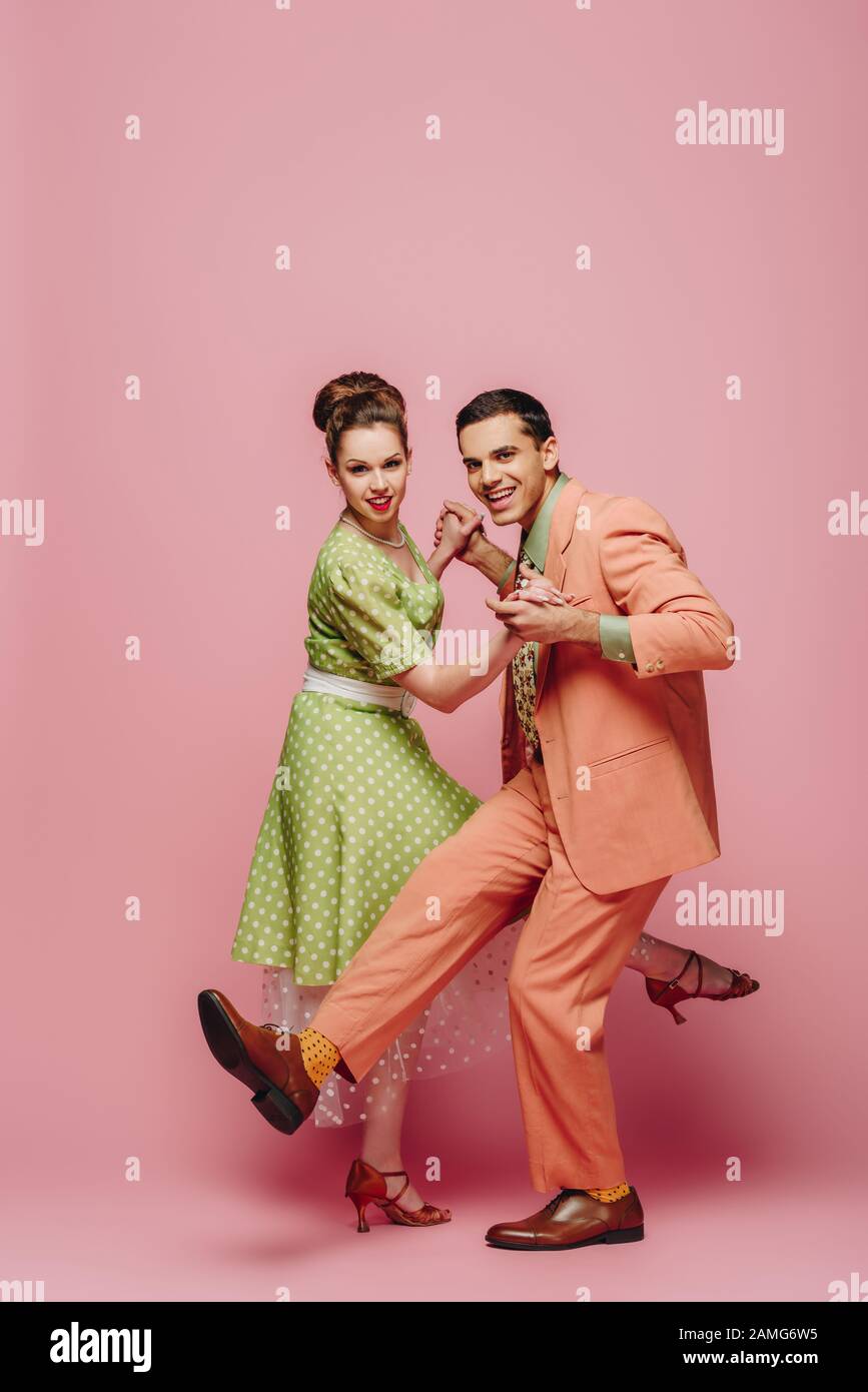 young dancers holding hands while dancing boogie-woogie on pink ...