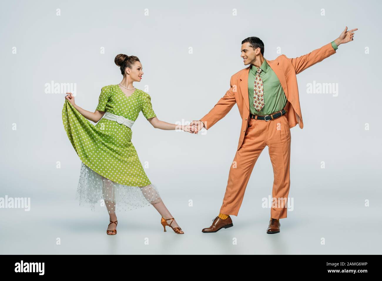 stylish dancers holding hands and looking at each other while dancing ...