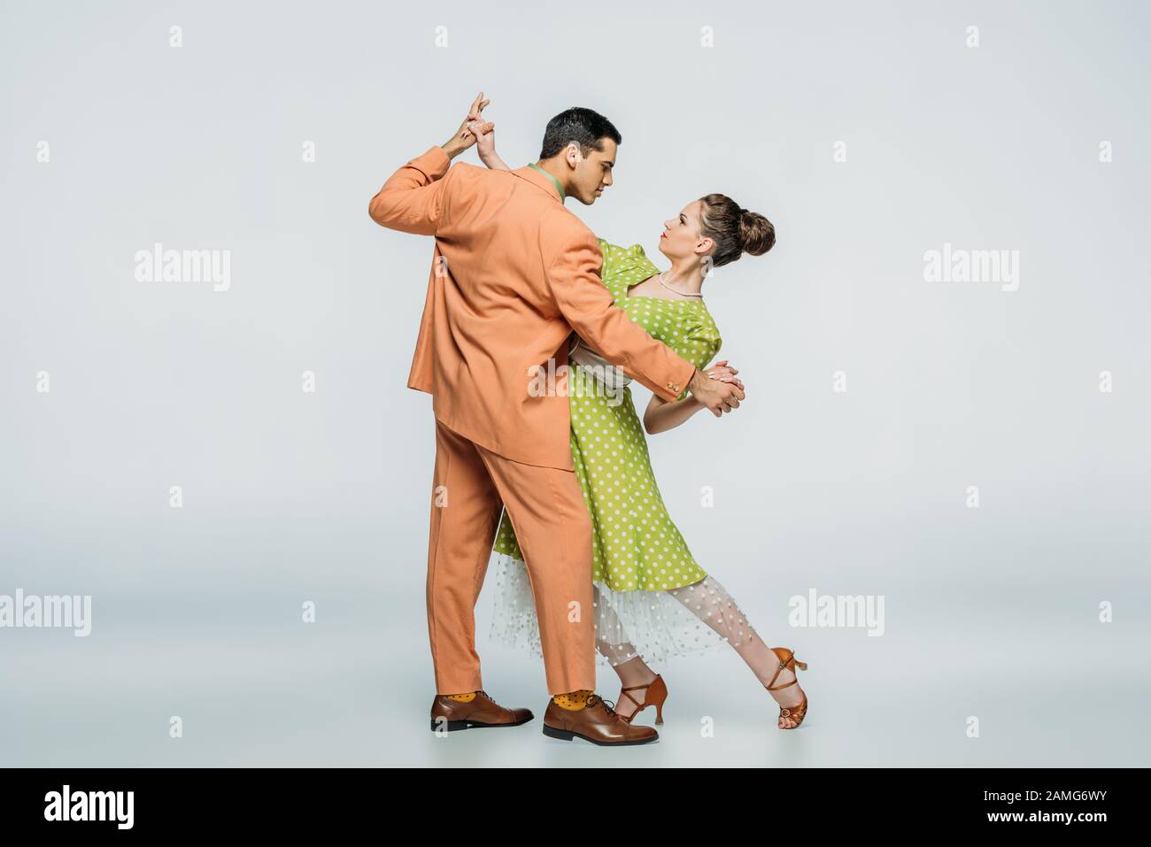 stylish dancers looking at each other while dancing boogie-woogie on ...