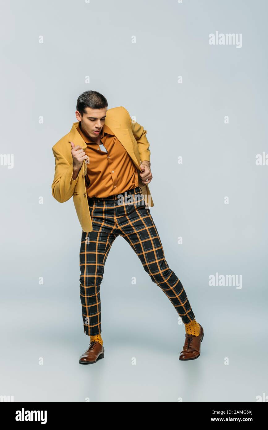 good-looking, stylish dancer dancing boogie-woogie on grey background ...