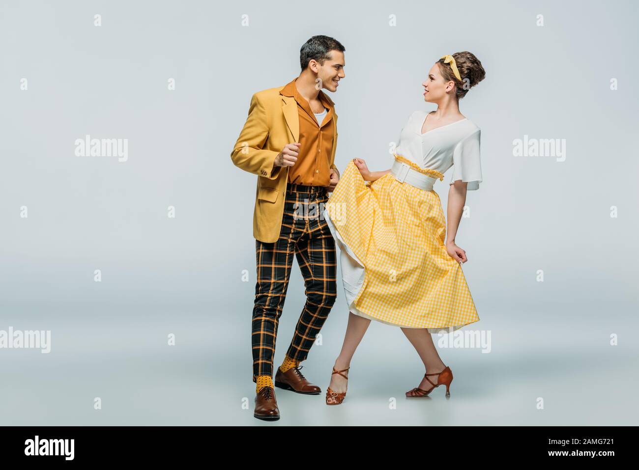 stylish dancers looking at each other while dancing boogie-woogie on ...