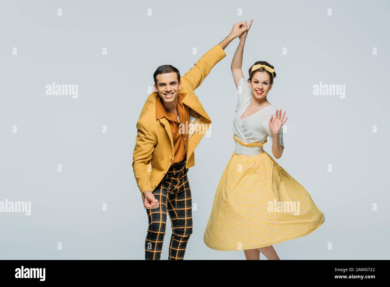 happy dancers holding hands while dancing boogie-woogie on grey ...
