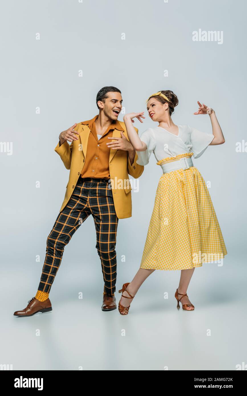 cheerful dancers looking at each other while dancing boogie-woogie on ...