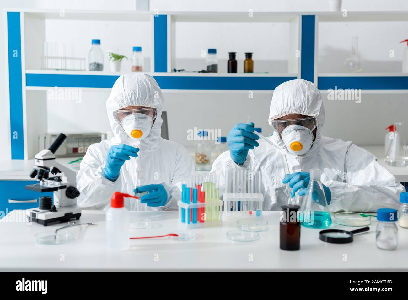 multicultural scientists in protective suits doing dna test in lab ...