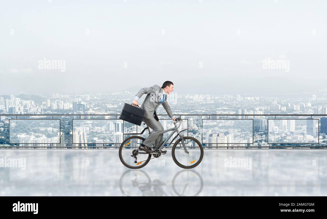 Man riding bicycle on penthouse balcony Stock Photo - Alamy