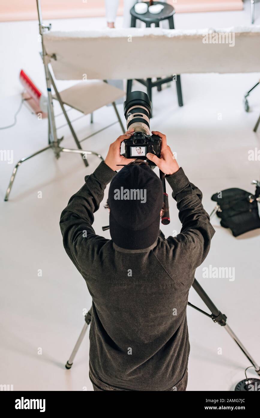 Overhead view of cameraman looking at camera display in photo studio ...
