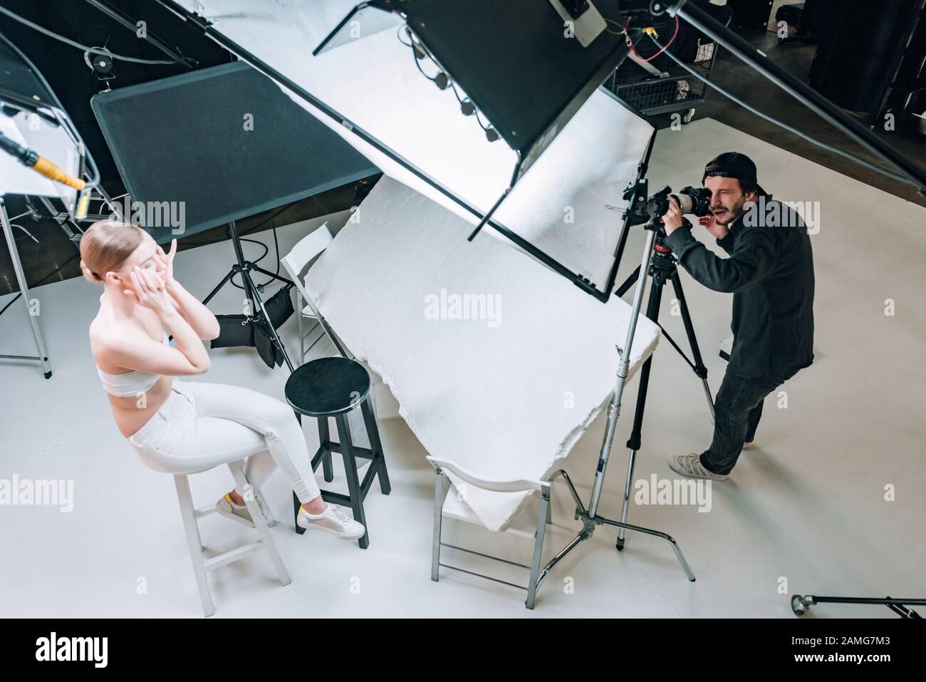Overhead view of beautiful model and videographer working in photo ...