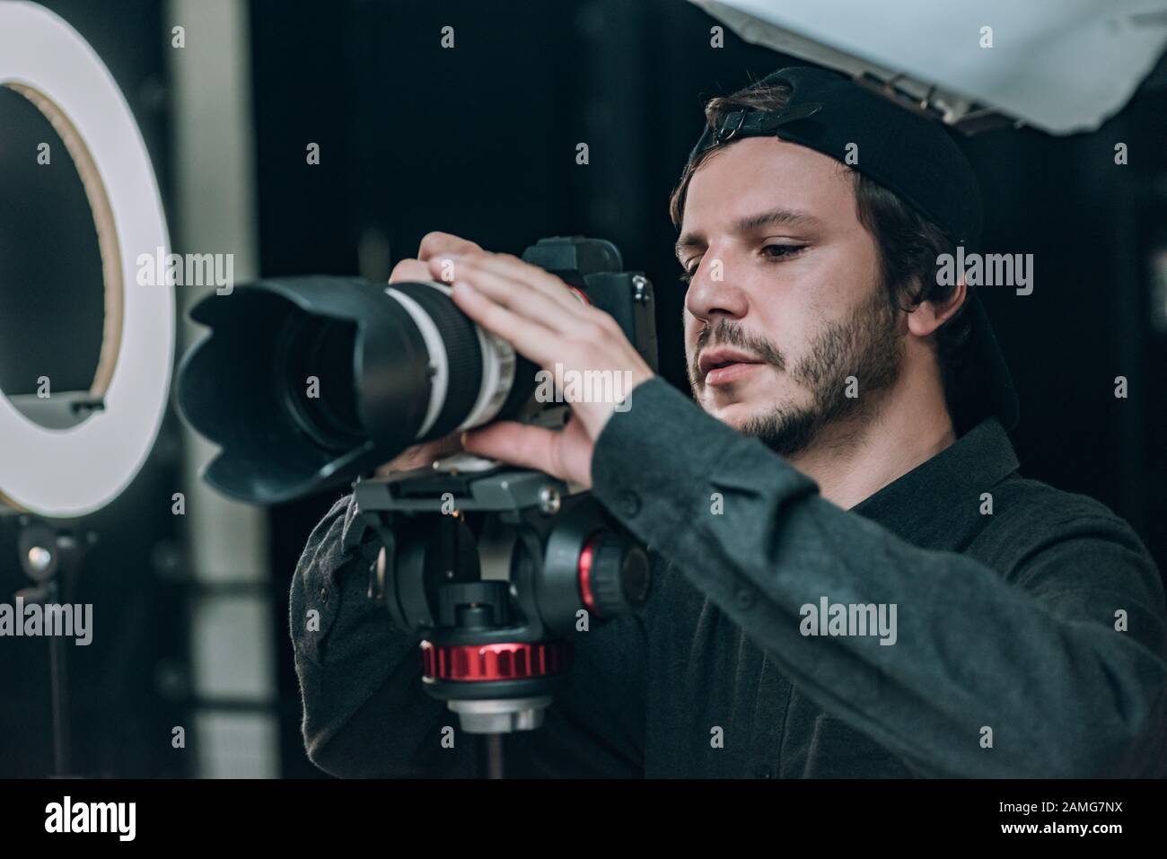 Handsome videographer looking at camera display in photo studio Stock ...