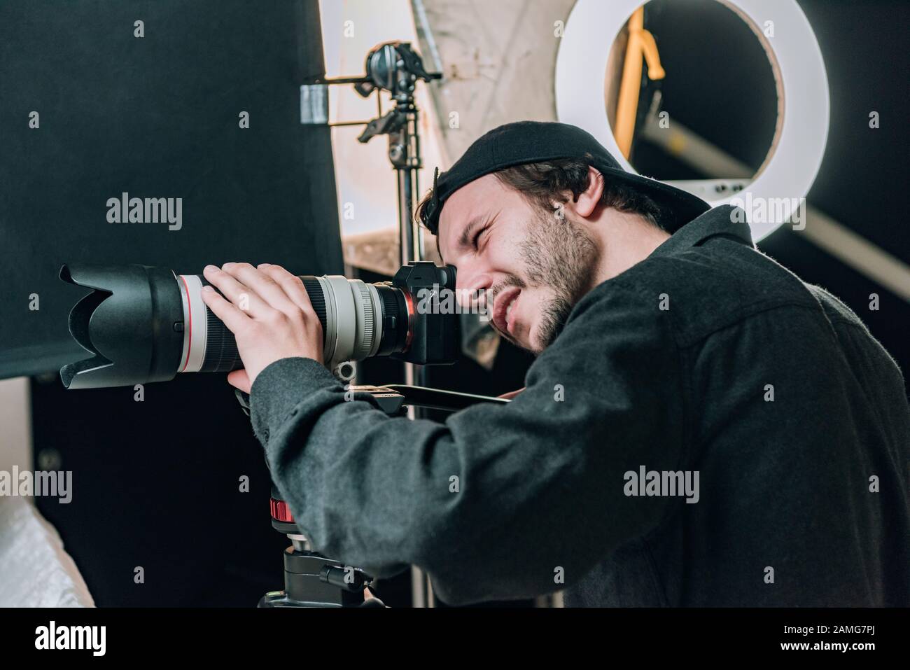 Side view of handsome cameraman working in photo studio Stock Photo - Alamy