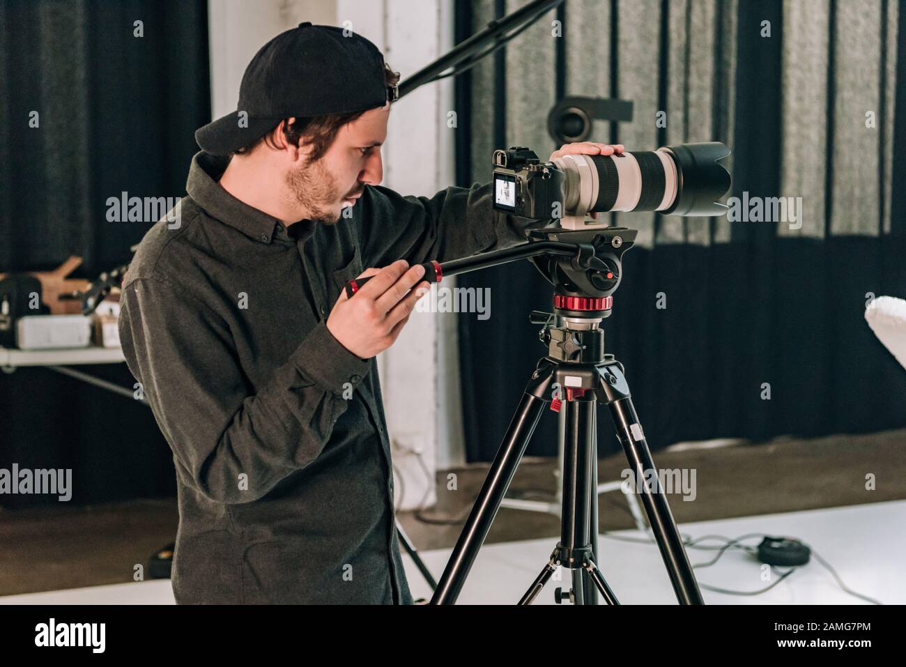 Side view of cameraman working in photo studio Stock Photo - Alamy