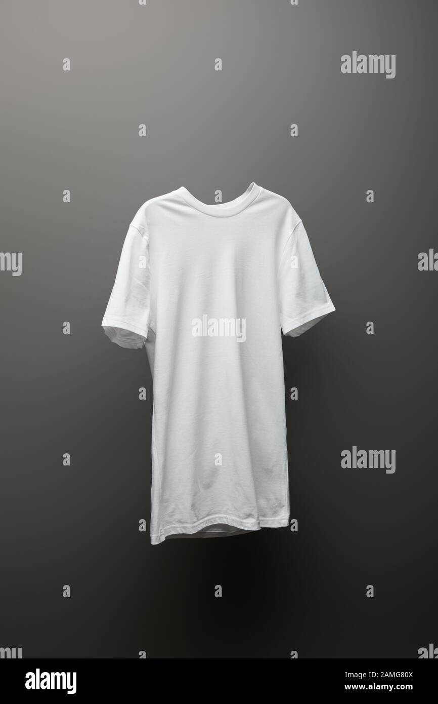 blank basic white t-shirt on grey background Stock Photo - Alamy