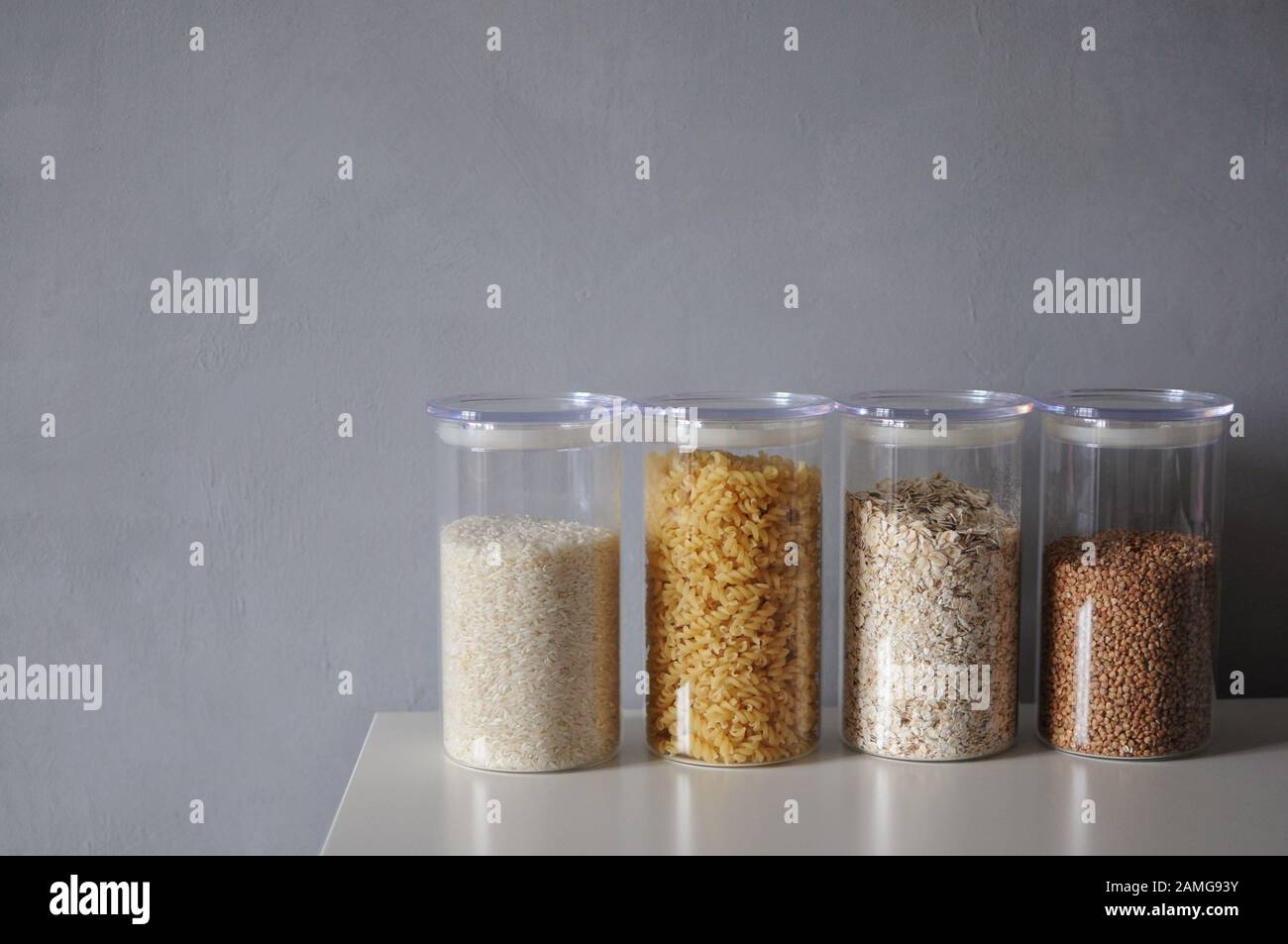 Various uncooked cereals for healthy cooking in a glass jars on grey ...