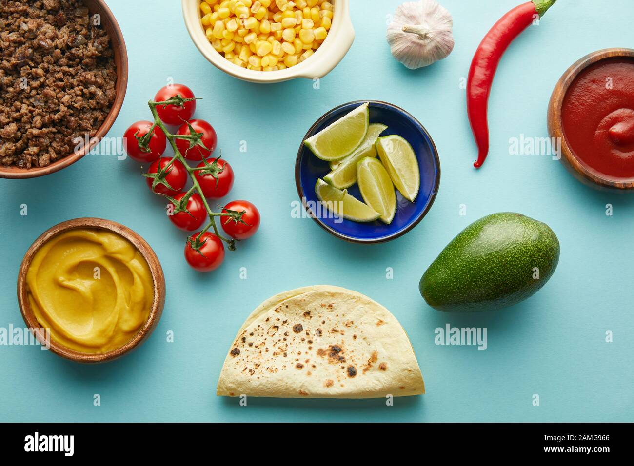 Top view of ingredients for taco with minced meat on blue background ...
