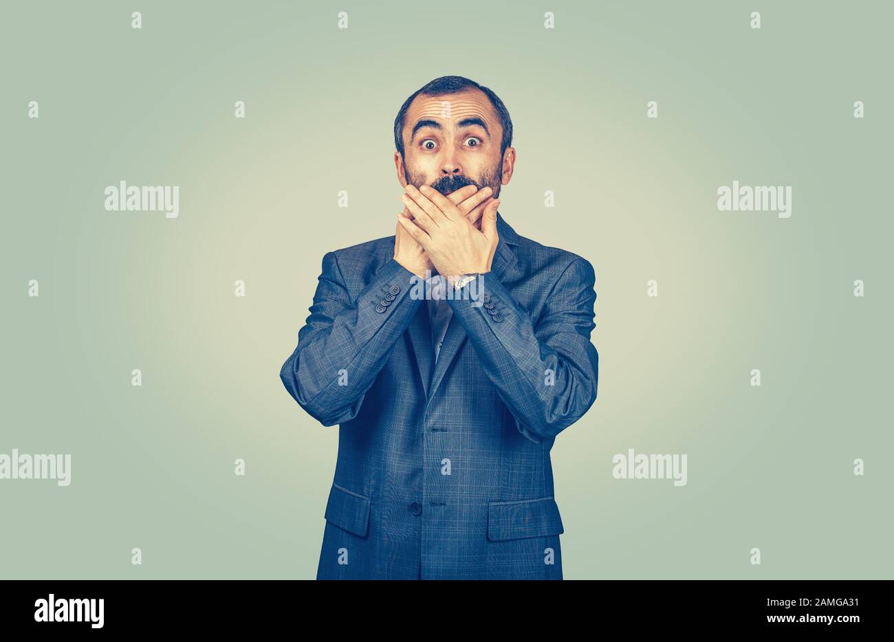 Portrait of shocked man covering mouth with hands. Isolated, half ...