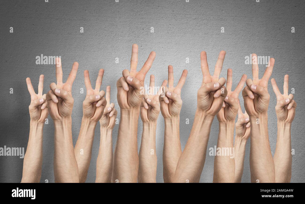 Row of man hands showing victory gesture Stock Photo - Alamy