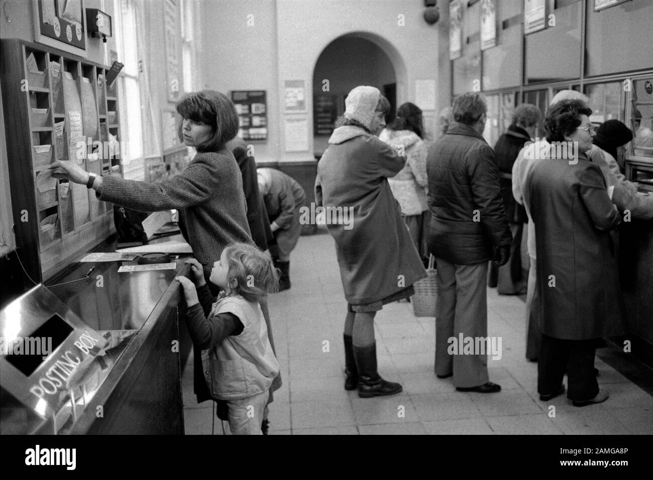 Post Office 1980s London UK. People filling in forms selecting leaflets ...
