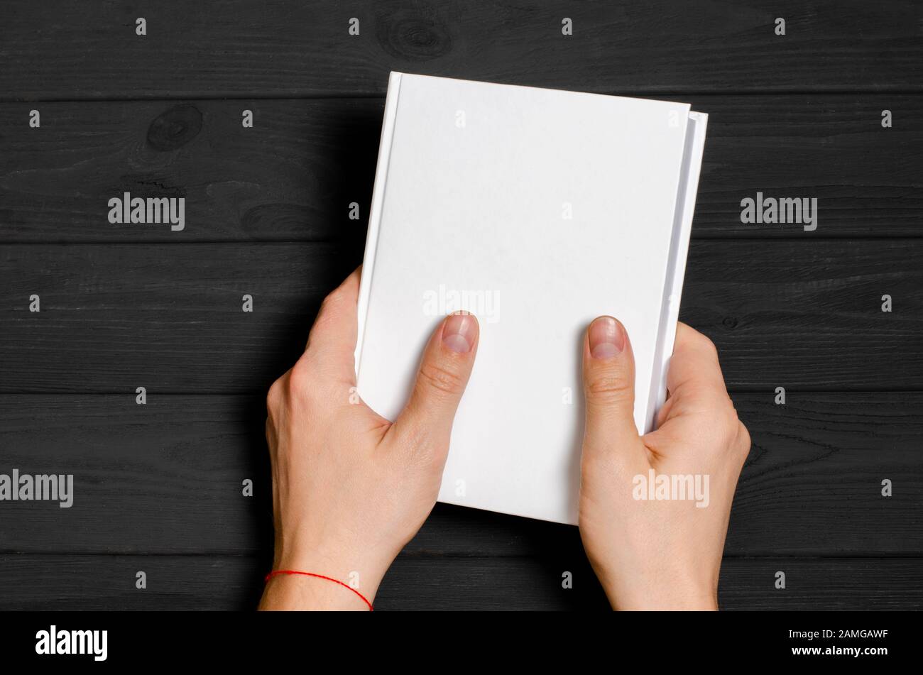 Men's hands holding closed book with blank cover on light background ...