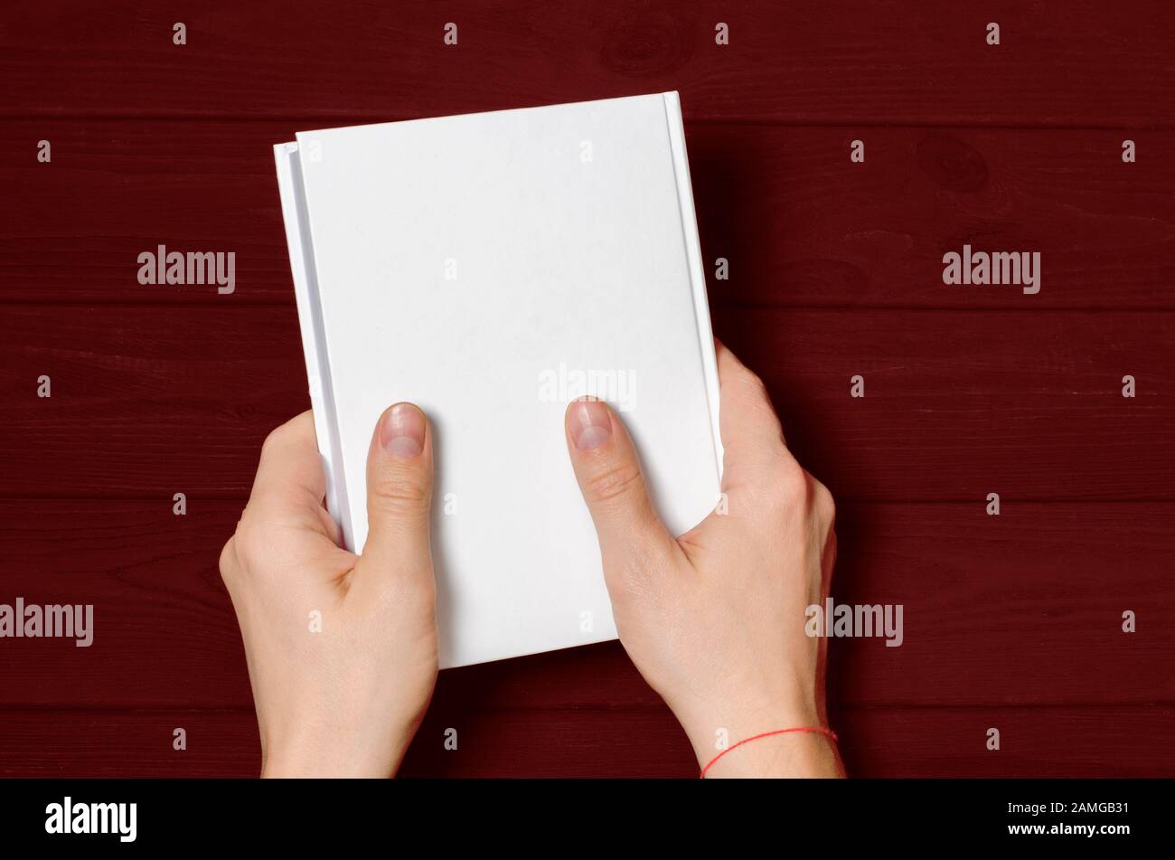 Men's hands holding closed book with blank cover on light background ...