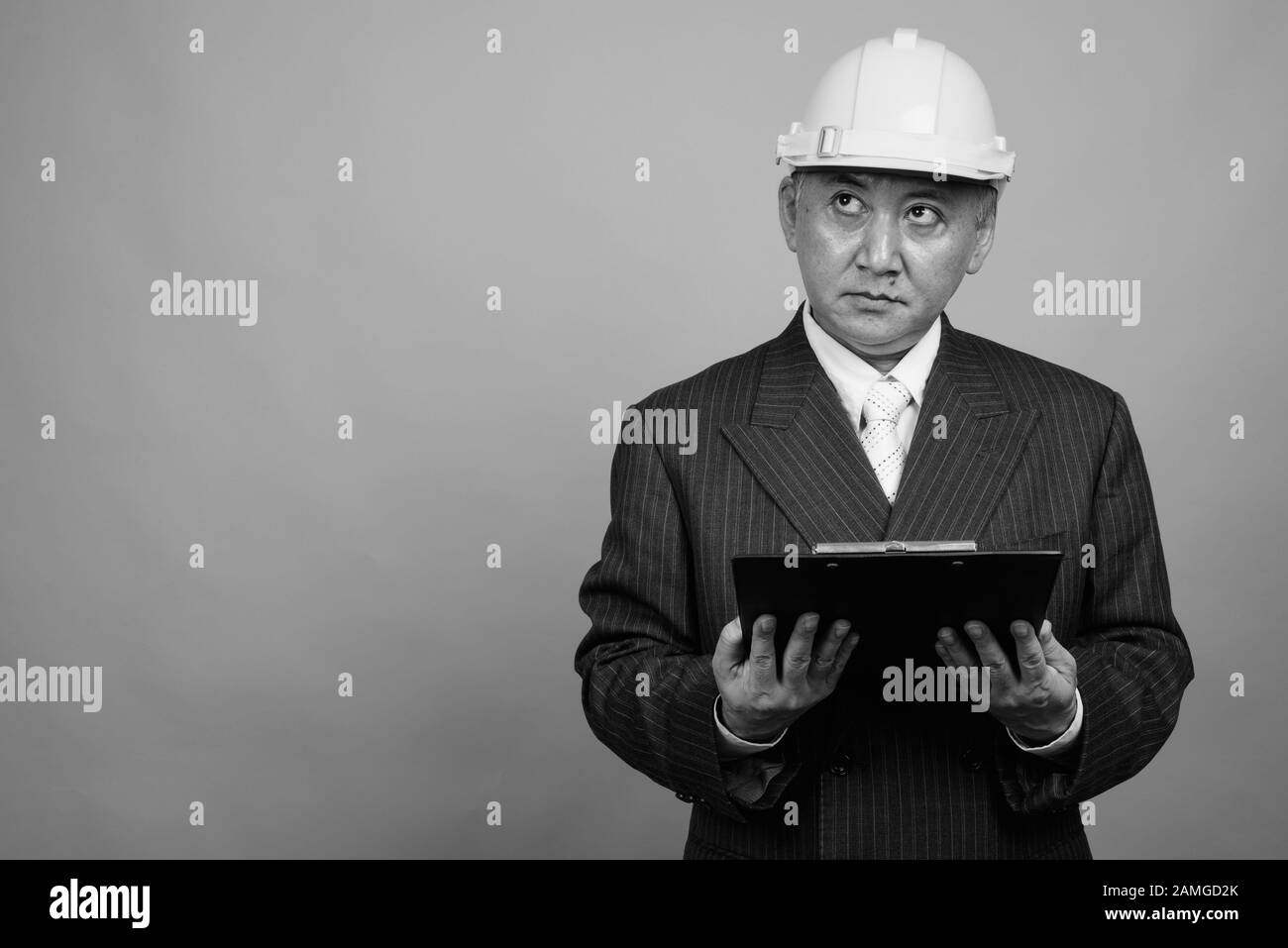 Studio shot of mature Asian businessman as engineer with hardhat ...