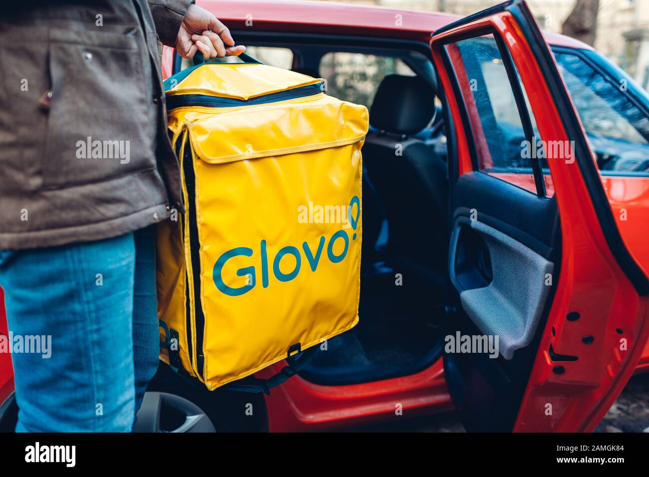 Lviv, Ukraine- January 13, 2020: Glovo delivery bag in car. Man worker ...