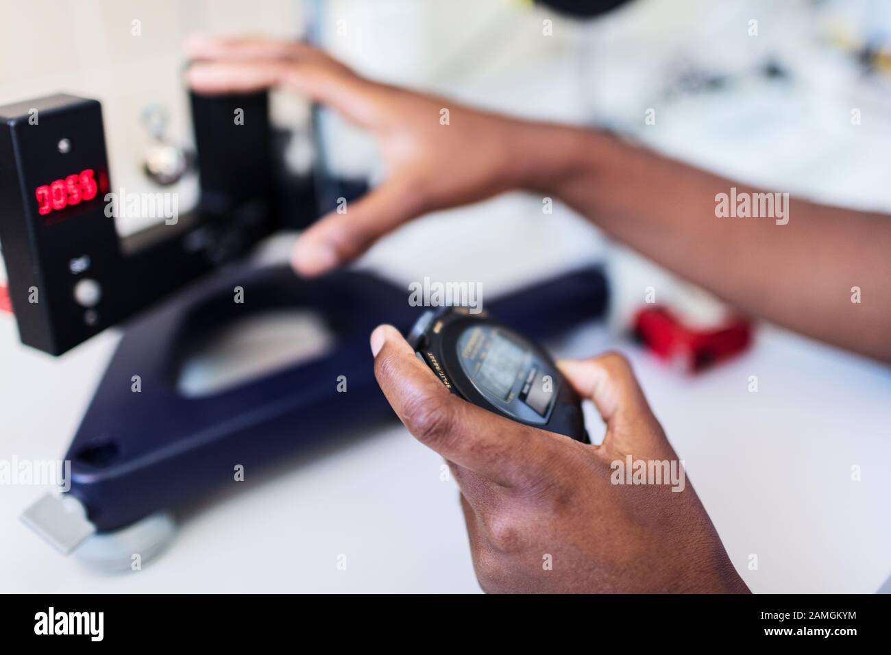 Scientist with laboratory clock and timer Stock Photo - Alamy