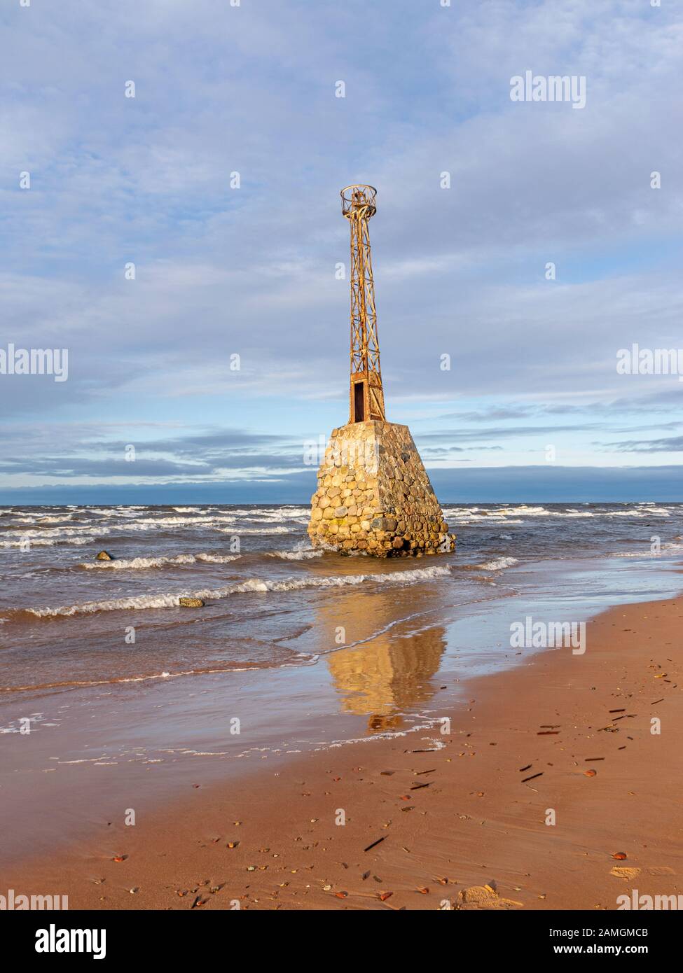 landscape with old and crooked lighthouse by the sea, windy day by the ...