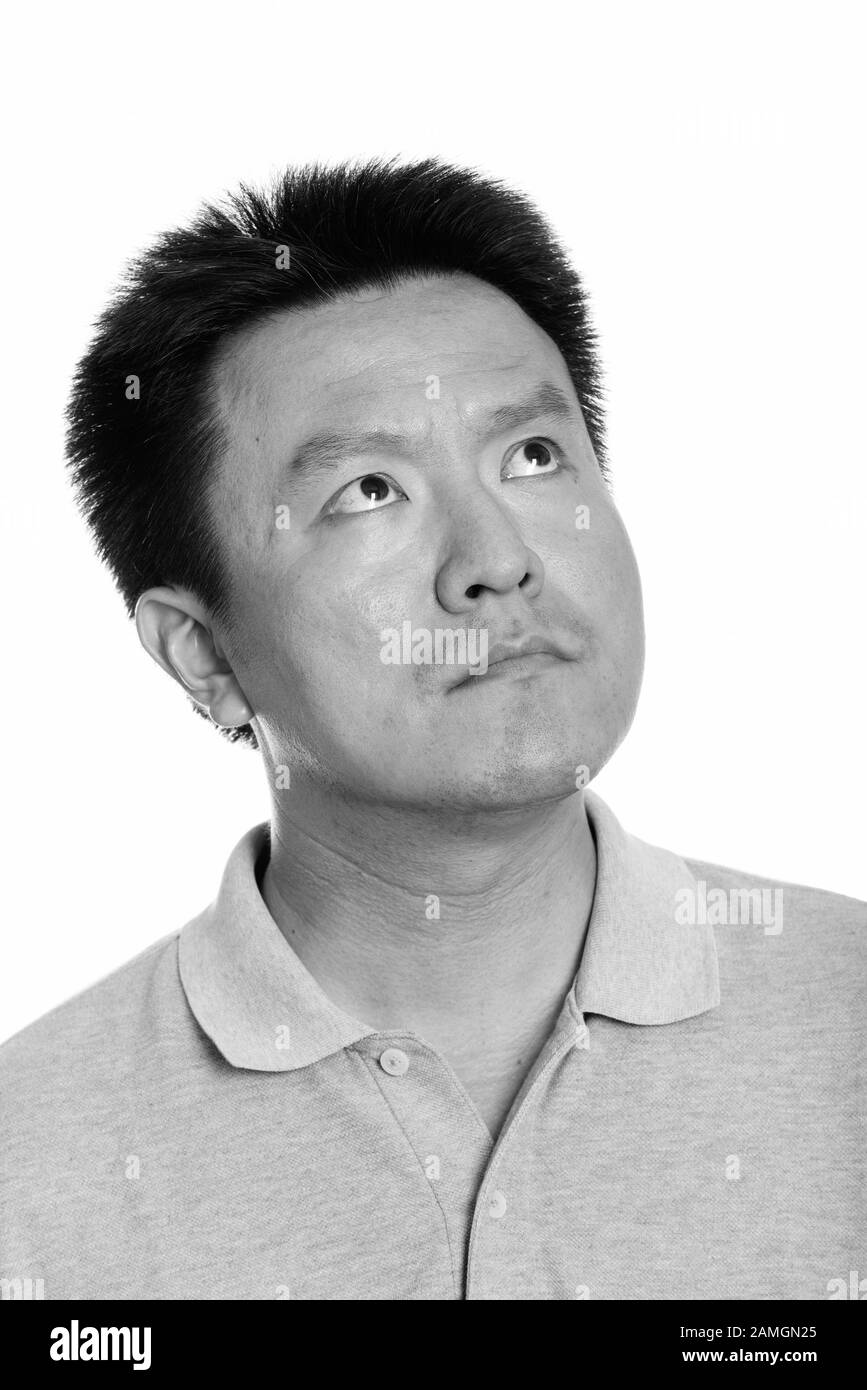 Face of Japanese man thinking while looking up Stock Photo - Alamy