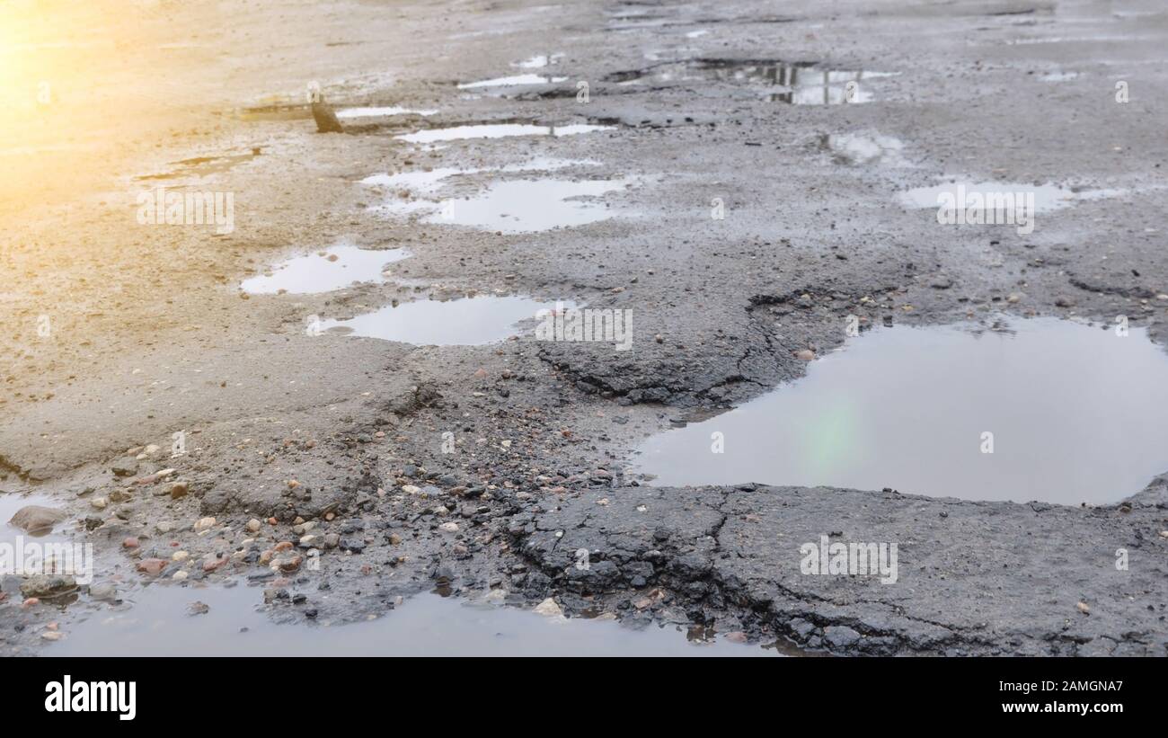 Poor road conditions. Holes in the asphalt, the risk of driving a car ...